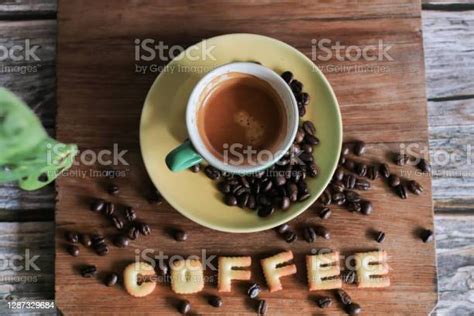 구운 커피 콩과 나무 배경에 작은 영어 편지 바삭바삭한 빵을 곁들인 화이트 컵의 커피 공간을 복사합니다 위에서 볼 수 있습니다 가로 방향입니다 0명에 대한 스톡 사진 및