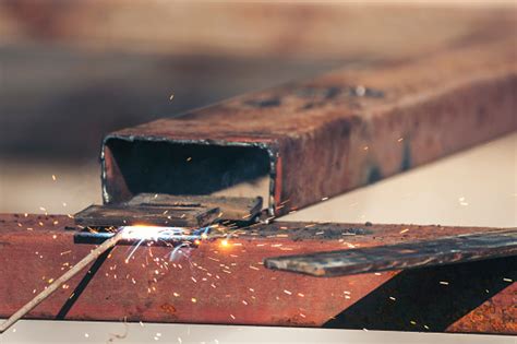 남자 손은 보호 장갑을 착용 뜨거운 화염 금속 작업 절단 화재 철 작업장 자물쇠 제조공은 용접기 절단 금속 공정을 사용합니다 용접 기계 철 금속 스파크를 사용하는 건설