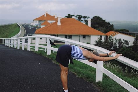 파란색과 흰색 줄무늬 셔츠와 검은색 반바지를 입은 사람이 회색 아스팔트 도로에 서 있는 동안 사진 Unsplash의 무료 건물 이미지