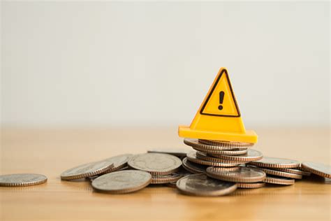 스택 동전에 노란색 경고 표시 라벨이 흰색 배경의 복사 공간이 있는 나무 테이블에 충돌합니다 은행에 대한 스톡 사진 및 기타 이미지 Istock