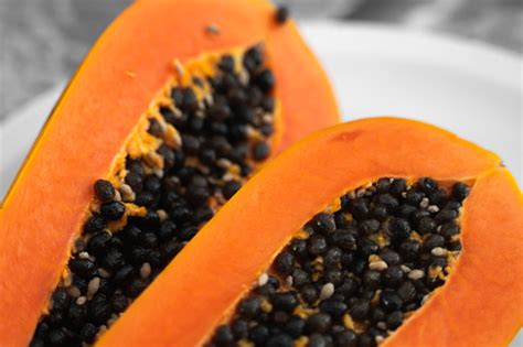 흰색 접시에 씨앗과 반 잘라 잘 익은 파파야 흰색 배경달콤한 파파야 조각 반으로 자른 파파야 건강한 이국적인 과일 채식 음식 0