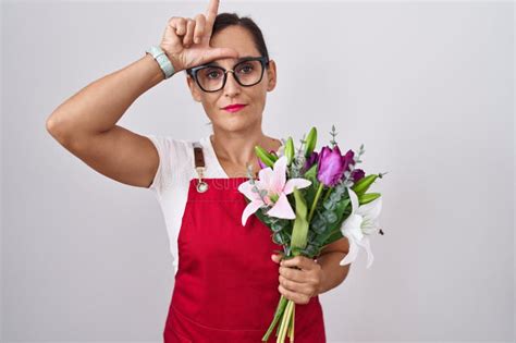 Middle Age Brunette Woman Wearing Apron Working At Florist Shop Holding