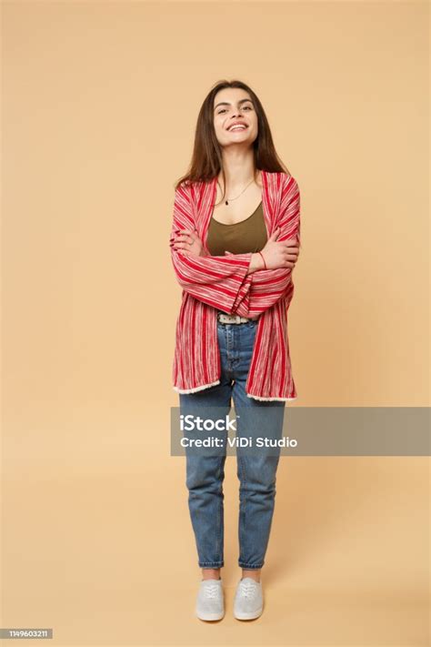 캐주얼에서 즐거운 젊은 여자의 초상화 카메라를 찾고 손을 잡고 스튜디오에서 파스텔 베이 지 배경에 고립 된 교차 사람들은