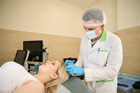 Woman Undergoing Surgical Excision Of Scalp Atheroma Performed By