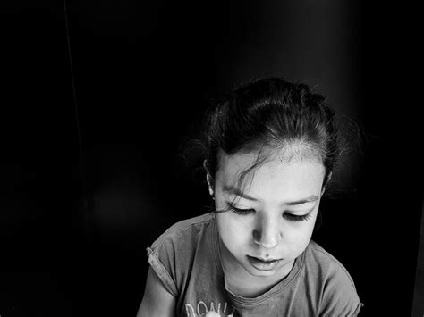 Premium Photo Cute Girl Looking Down Against Black Background