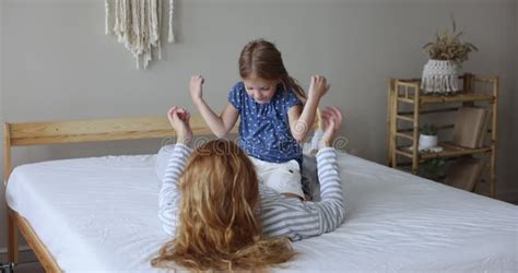 Young Mom Lying On Bed Play With Cute Little Daughter Stock Video