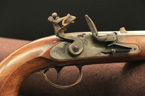 Closeup Of The Trigger And Flintlock With The Mounted Flint And Closed Tinder On The Black Closeup Of The Trigger And Flintlock With The Mounted Flint And Closed Tinder On The Black