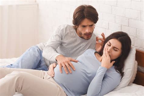Pregnant Woman Suffering From Morning Nausea Worried Husband Soothing