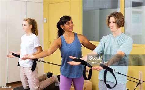 필라테스 강사 도움 대 소년 과 소녀 할 손 스트레칭 에 그만큼 기계 에 체육관 12 13세에 대한 스톡 사진 및 기타 이미지