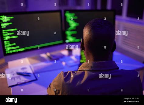 Rear View Shot Of Unrecognizable African American Computer Programmer Sitting In Front Of