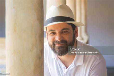 흰색 폴로 셔츠와 에콰도르에서 만든 아름다운 파나마 모자를 입은 라틴 브라질 배낭 여행자 관광객이 브라질 주아오 페소아에서 얼굴과 식민지 기둥을 등에 색칠했습니다 35 39