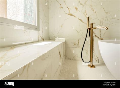detail of a bathroom with marble walls a continuous bench made of the