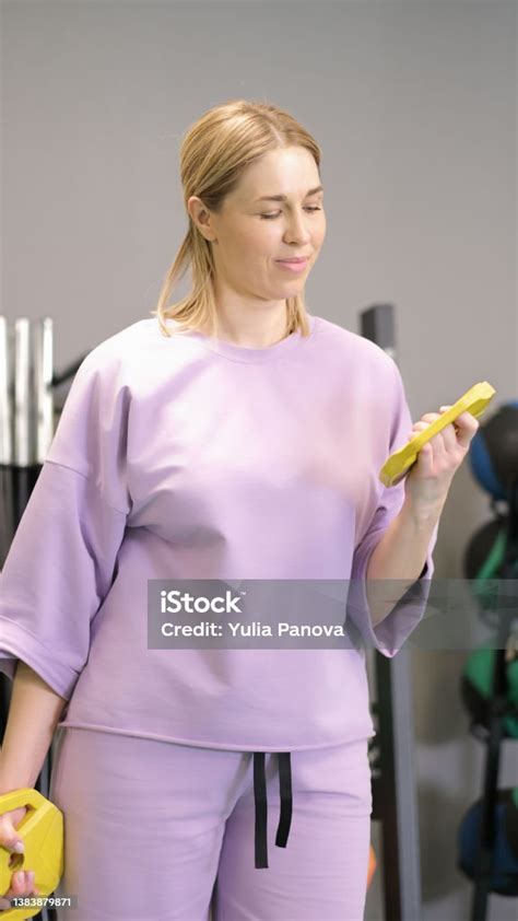 체육관에서 팔과 삼두근을 운동하기위한 가벼운 디스크를 들고 있는 여성 운동 과 체중 감량과 체 지방 감량에 대 한 운동 수직