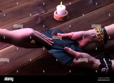 fortune teller s hands with prediction cards on a wooden background the oracle visitor draws a