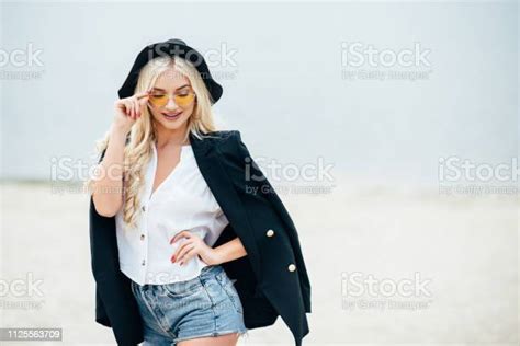 안경에 귀여운 금발 여자는 해안을 따라 산책 하 고 인생을 즐길 긴에 대한 스톡 사진 및 기타 이미지 긴 머리 모자 모자류 Istock