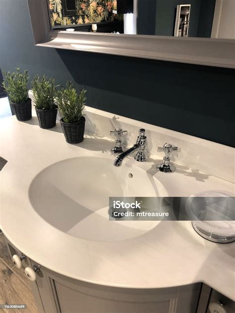 세라믹 타원형 싱크대와 스테인레스 스틸 믹서 탭과 인공 집 화분 현대 대형 회색 화강암 돌 타일 화장실 벽에 매달려 직사각형 큰 거울과 현대 흰색 고급 화장실 욕실 스위트의