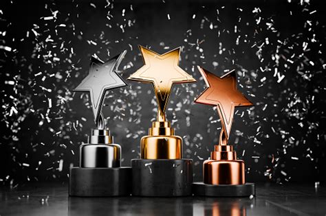 우승자 컵은 대회에서의 승리와 성공을 상징하는 축제 색종이 조각으로 둘러싸여 있습니다 우승자 상금 연단 은 동메달 금메달 챔피언 연단에서의 승리 금 금속에 대한 스톡 사진