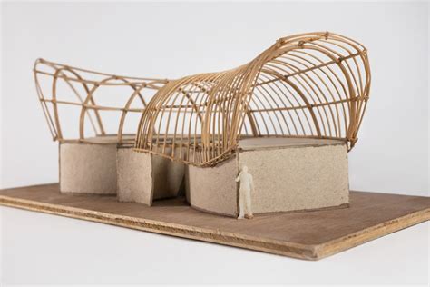 A Small Model Of A House Made Out Of Concrete Blocks With A Birdcage On Top