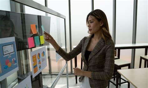 Premium Photo A Woman Stands In Front Of A Glass Wall With Post It Notes On It