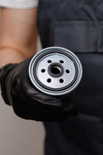 장갑을 낀 자동차 정비사가 디젤 자동차의 연료 필터를 손에 들고 클로즈업하여 돌립니다 자동차 유지 보수 및 수리 연료 필터 교체