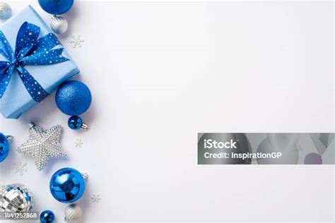 크리스마스 개념입니다 리본 활 디스코 공 빛나는 별 장식과 복사 공간이 있는 격리된 흰색 배경에 색종이가 있는 파란색 흰색 은색 싸구려 선물 상자의 상위 뷰 사진