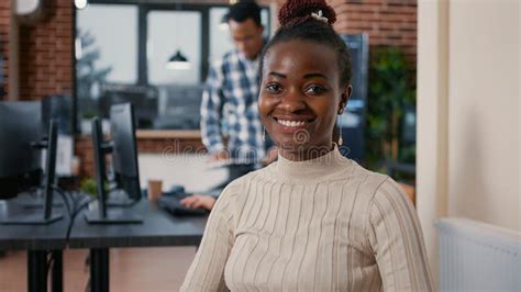 Portrait Of African American Programer Sitting Down Coding On Laptop Looking Up And Smiling