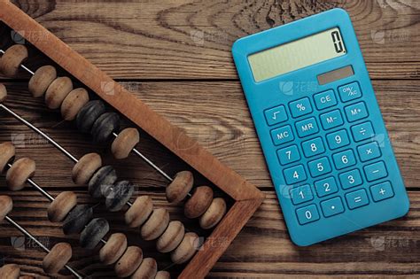 木制背景上的老式算盘和计算器。前视图。