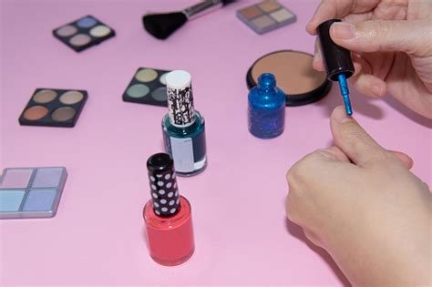 파란색 매니큐어로 손톱을 칠하는 여자의 손을 닫습니다 파스텔 핑크 백그로에 코스메틱 세트 갈색에 대한 스톡 사진 및 기타 이미지 갈색 개념 개념과 주제 Istock