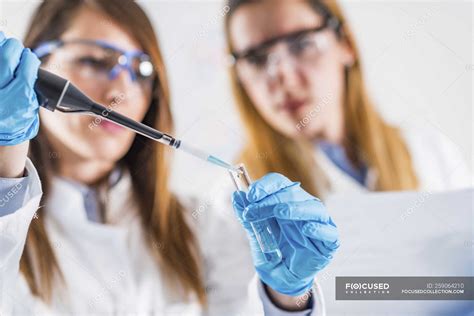 Female Researchers Using Micropipette In Laboratory Women Protective Eyewear Stock Photo