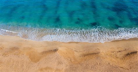 들어오는 푸른 파도가 있는 목가적인 바다 모래 해변의 공중 전망 열대 지방의 휴일과 휴식의 개념 여행과 휴가의 배경 사진 Unsplash의 사람이 없다 이미지