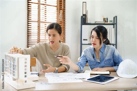 Concept Of Engineering Consulting Two Female Engineers Pointing And Discussing Model Of