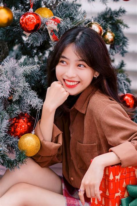 실내 가벼운 갈색 자켓 겨울 계절 계절 장식 금 장식품 기분 좋은 따뜻한 조명 밝은 색 빨간 장신구 빨간색 선물 상자 선명한 선물 선물주기