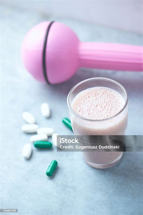 우유와 라즈베리가 포함 된 단백질 셰이크 유리 Bcaa 아미노산 L카 르 니 틴 캡슐 및 핑크 아령 배경 스포츠 영양 돌 나무 배경입니다 복사 공간 0명에 대한 스톡 사진