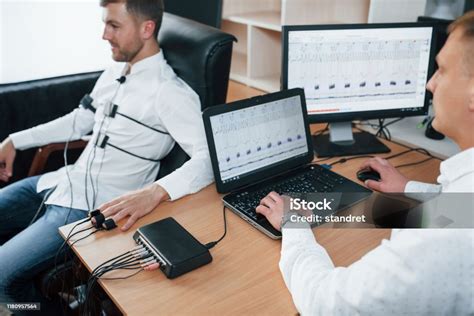 처음 그 안전을 보았을 때 를 기억하십니까 의심스러운 남자는 사무실에서 거짓말 탐지기를 전달합니다 질문 폴리그래프 테스트 2명에 대한 스톡 사진 및 기타 이미지 Istock