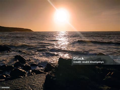 바위가 많은 해안선 너머로 황금빛 석양 이 고요한 바다 풍경에서 파도가 돌에 부딪힙니다 여행 자연 또는 사색적인 개념에 이상적입니다 0명에 대한 스톡 사진 및 기타 이미지