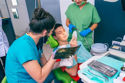 치과 사무실에서 어린 소년 환자에게 치아 엑스레이 이미지를 보여주는 남성과 여성 치과 의사 14 15 살에 대한 스톡 사진 및 기타 이미지 Istock