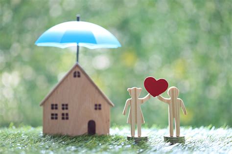 보호 자연 녹색 배경에 우산 아래 모델 하우스와 동전 돈의 스택에 서 심장 모양을 들고 사랑 커플 안전한 투자와 미래 개념에