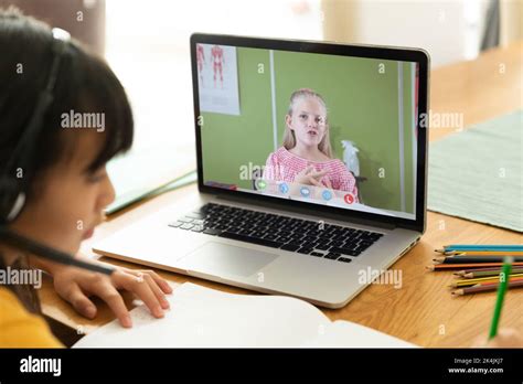 Asian Girl Using Laptop For Video Call With Caucasian Elementary
