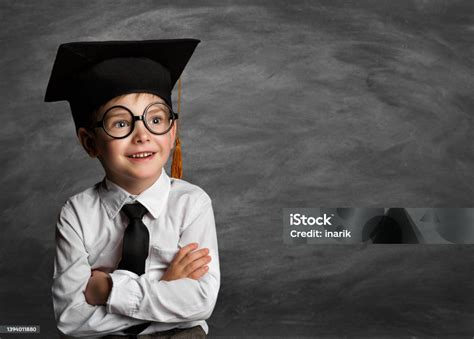 안경과 졸업 모자를 쓴 행복한 아이가 칠판을 생각하며 칠판 위의 안경을 쓴 쾌활한 미소 짓는 유치원 소년 영리한 어린이 초등 교육 넥타이에 대한 스톡 사진 및 기타 이미지