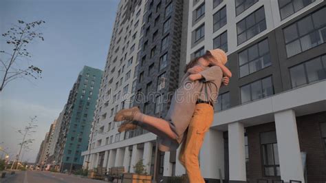 The Guy Picks Up The Girl In His Arms And Circles On The Street Stock