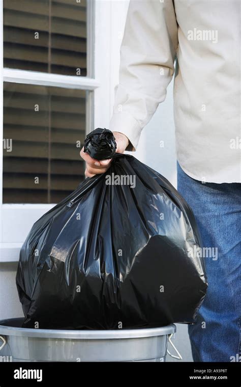Man Putting Garbage Bag Into Trash Can Mid Section Stock Photo Alamy