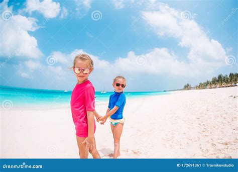 Little Happy Funny Girls Have A Lot Of Fun At Tropical Beach Playing