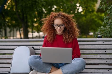 Premium Photo Redhead Student Using Laptop In Park