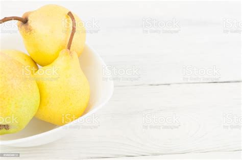 오래 된 소박한 흰색 나무 테이블에 흰색 세라믹 그릇에 신선한 익은 노란색 전체 배나무의 힙 건강한 식생활에 대한 스톡 사진 및 기타 이미지 Istock