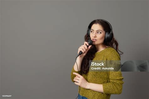 마이크에 노래를 노래 헤드폰 캐주얼 옷을 입고 쾌활한 젊은 여성 복사 공간을 조롱 가수에 대한 스톡 사진 및 기타 이미지 가수 갈색 머리 곱슬 머리 Istock