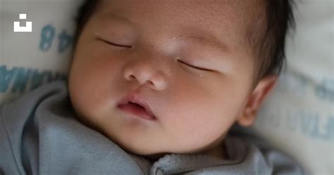 침대에 누워 있는 회색 옷을 입은 아기 사진 Unsplash의 무료 신생아 이미지