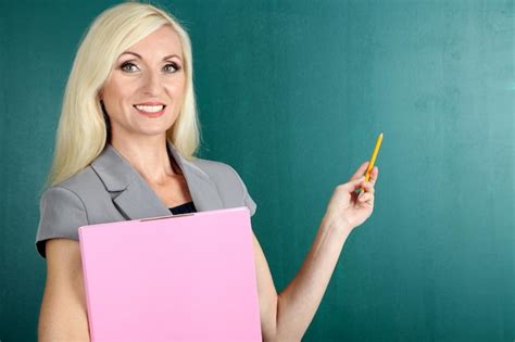 Premium Photo School Teacher With Folder Near Blackboard Closeup