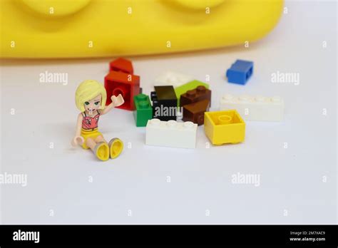 Lego Mini Figures Next To A Pile Of Lego Blocks With A Large Block In