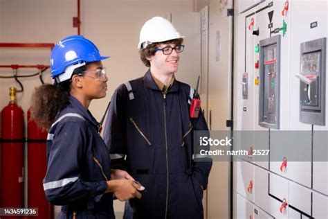 전기 젊은 여성과 남자 엔지니어는 산업 공장 기술자 또는 전기 검사 전력 분배의 제어실에서 유지 보수 캐비닛 시스템 전기를
