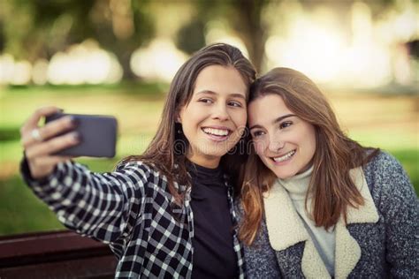 Theres Always Time For A Selfie Two Attractive Young Women Taking Selfies While Sitting In The